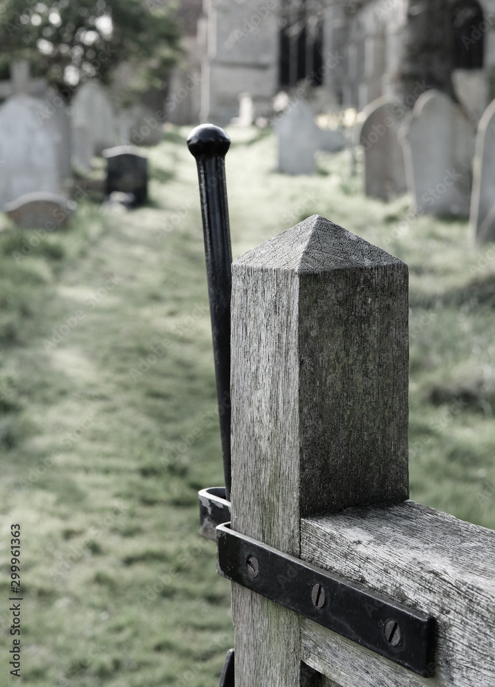 Timber built gated entrance seen at an old village cemetery, showing ...