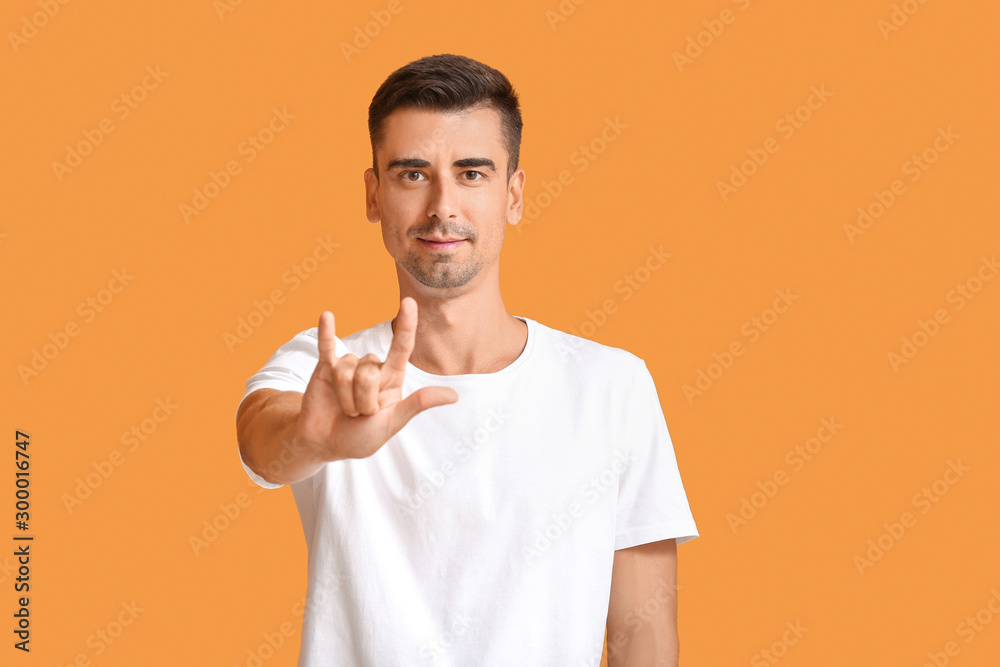Young deaf mute man using sign language on color background Stock Photo ...