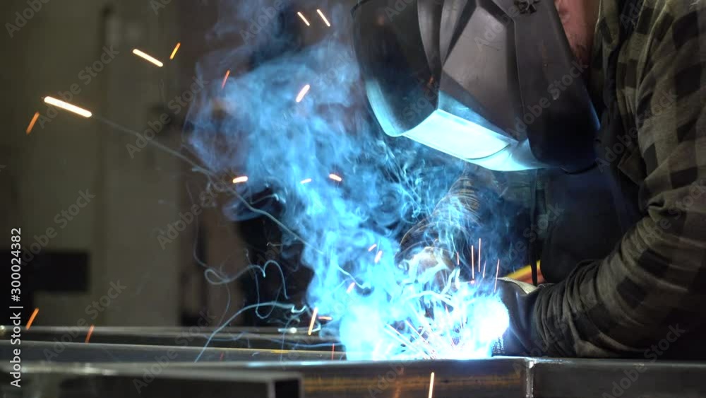 Worker in the helmet welds a structure made of steel profiles Stock ...