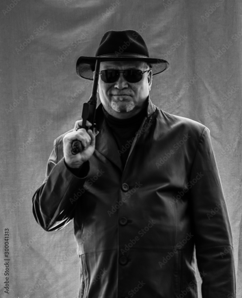 Foto de A man in black clothes, a black leather coat, hat. Ganster with ...