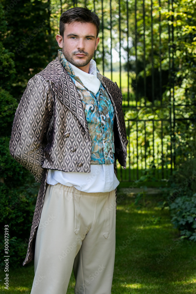Portrait of handsome gentleman dressed in vintage costume standing in ...