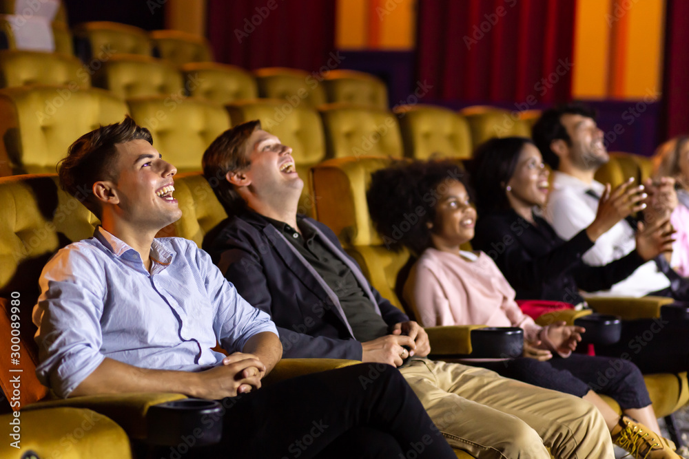 Laughing casual men sitting on soft chairs and laughing while watching ...