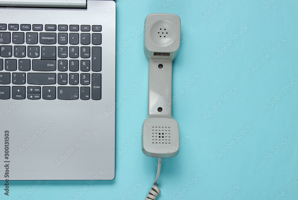 Laptop and handset on a blue background. Minimalistic office concept ...