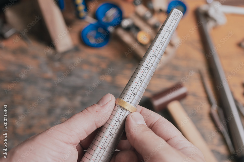 golden ring on a ring sizer gauge, jeweler sizing tool from steel ...