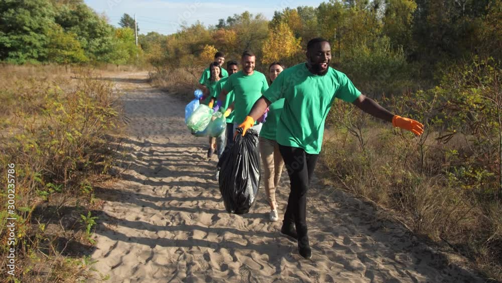 Cheerful group of multi-ethnic activists with garbage bags having fun ...