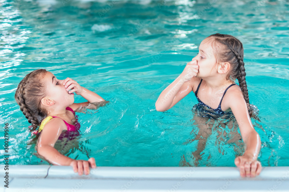 Two little girls swim in the pool. Two friends in the pool.Children ...