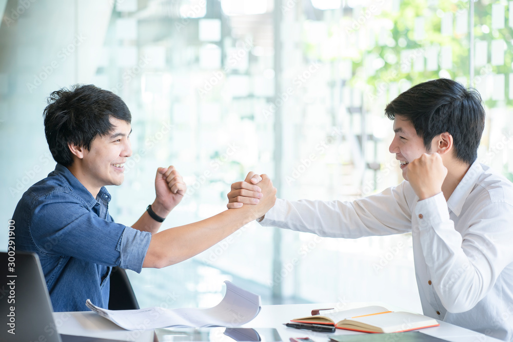 Businessmen shaking hands at the office. Friendly arm wrestling fist up ...
