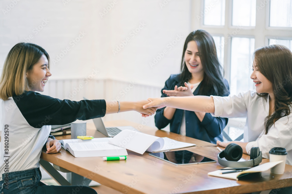 Young students shaking hands in the library campus. Happy people ...