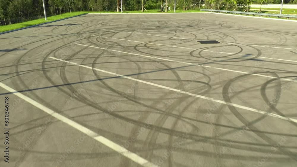 Low aerial footage of a parking lot with race car track skid marks ...