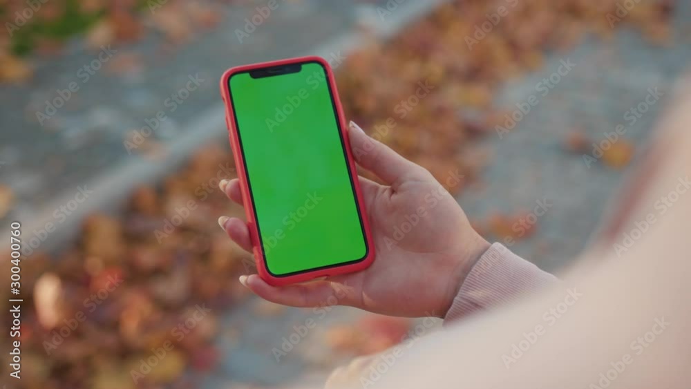 Hands woman holding use vertical phone with green screen at sunny day typing scrolling pages ...
