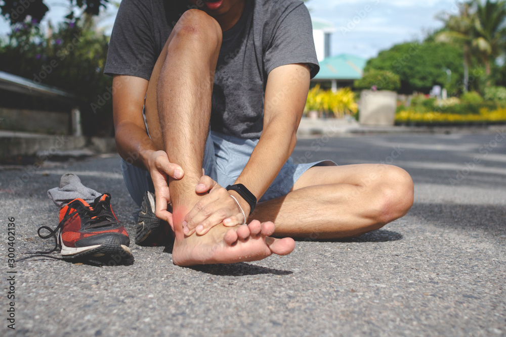 Sport man holding ankle in pain due to sprained ankle. Injury from ...