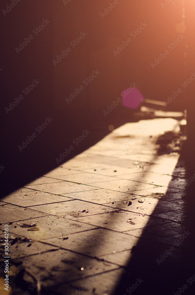 Shadows and light on the floor with broken glass and broken ...