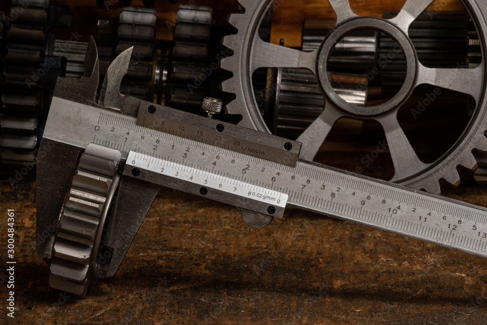 vernier callipers, micrometer and bore gauge on a workbench with gears ...