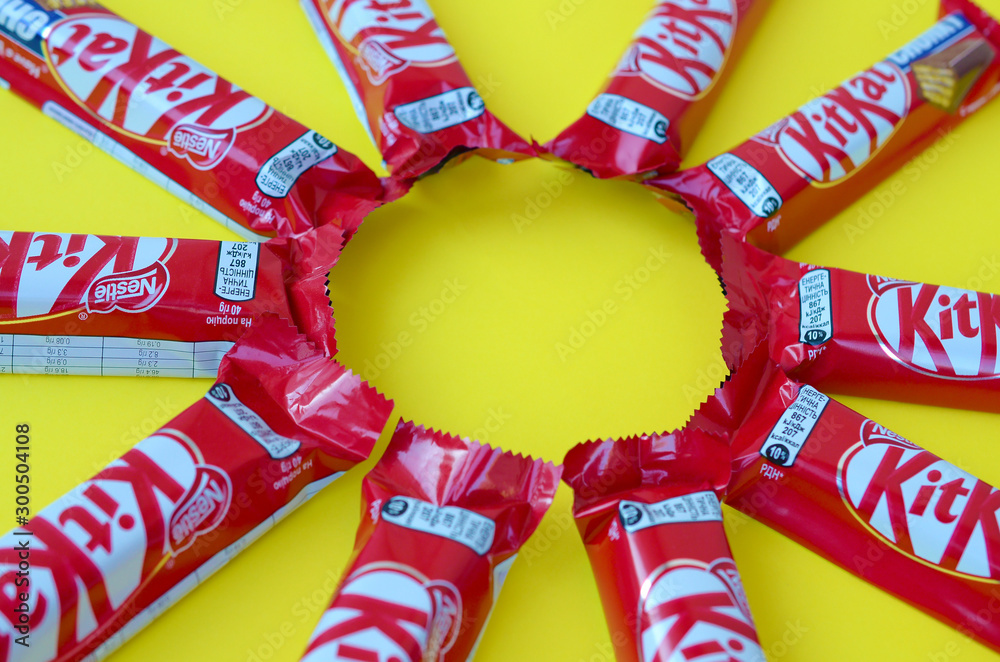 Kit Kat chocolate bars in red wrapping lies on yellow background. Kit ...