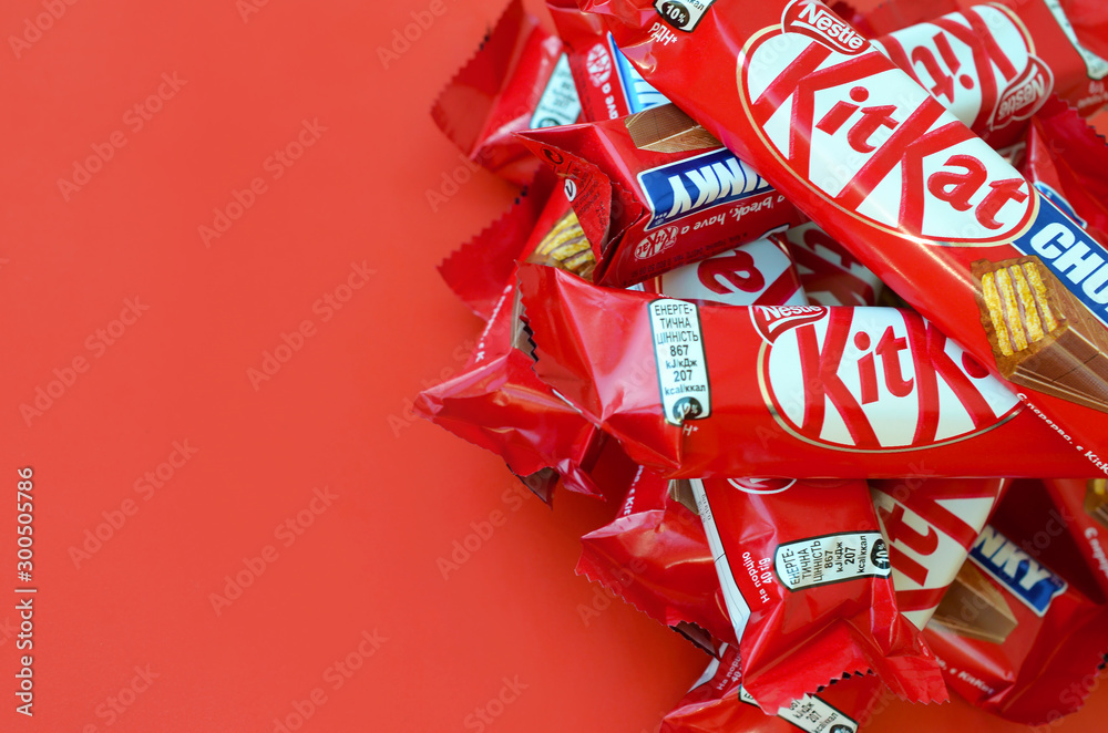 Kit Kat chocolate bars in red wrapping lies on yellow background is now ...