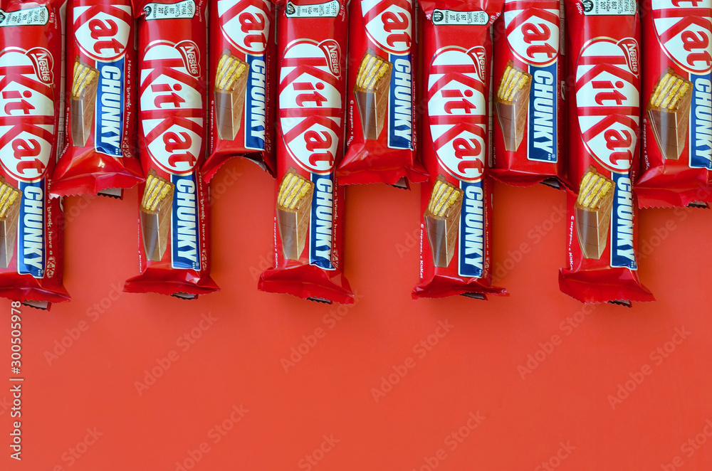 Kit Kat chocolate bars in red wrapping lies on yellow background is now ...