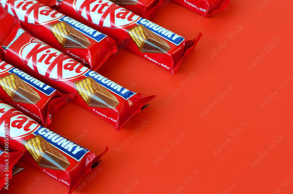 Kit Kat chocolate bars in red wrapping lies on yellow background is now ...