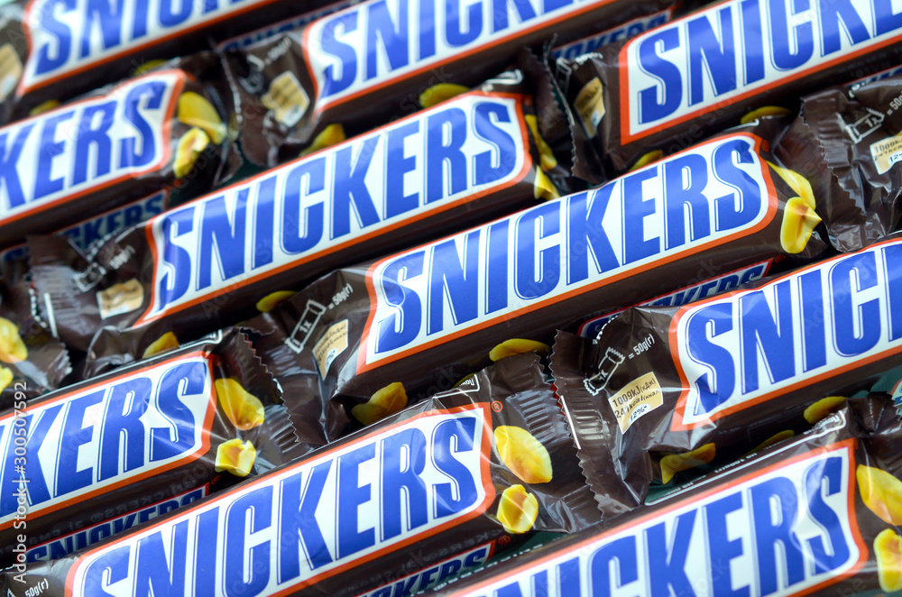 Many Snickers chocolate bars stacked close up. Snickers bars are ...