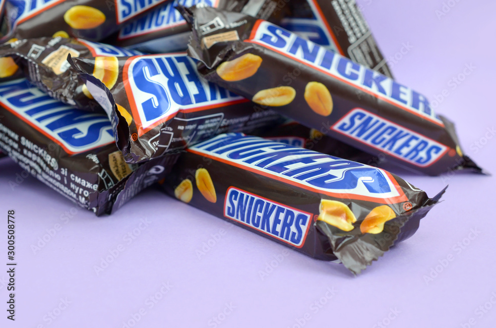 Many Snickers chocolate bars stacked close up. Snickers bars are ...