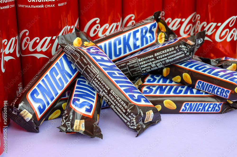 Snickers chocolate bars in brown wrapping lies on bright violet ...