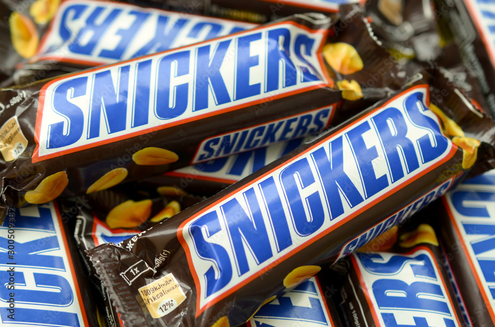 Many Snickers chocolate bars stacked close up. Snickers bars are ...