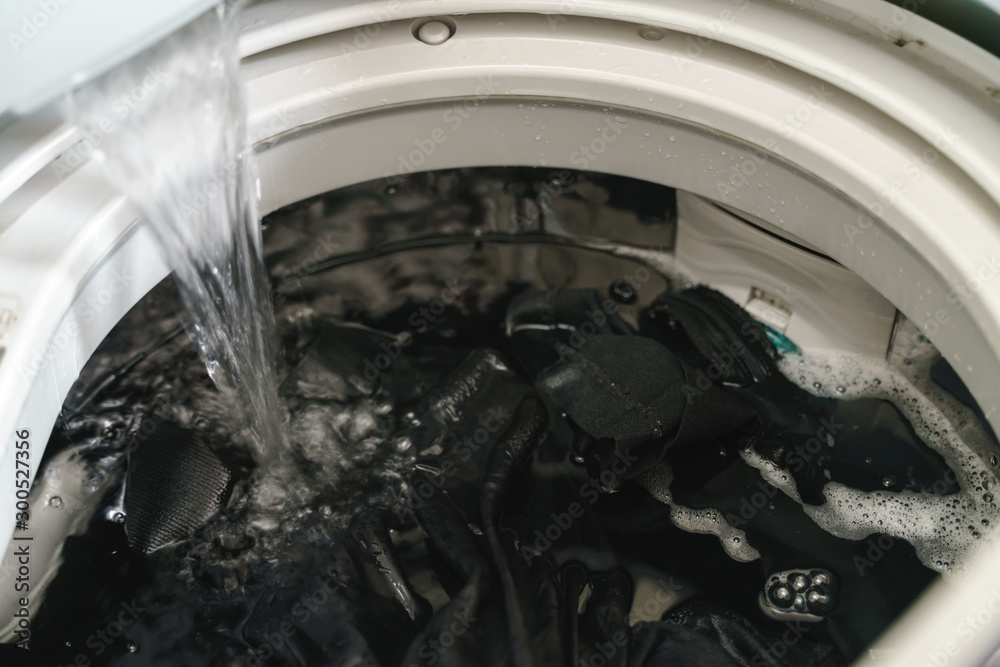 Laundry clothes in top loading washing machine Stock Photo | Adobe Stock