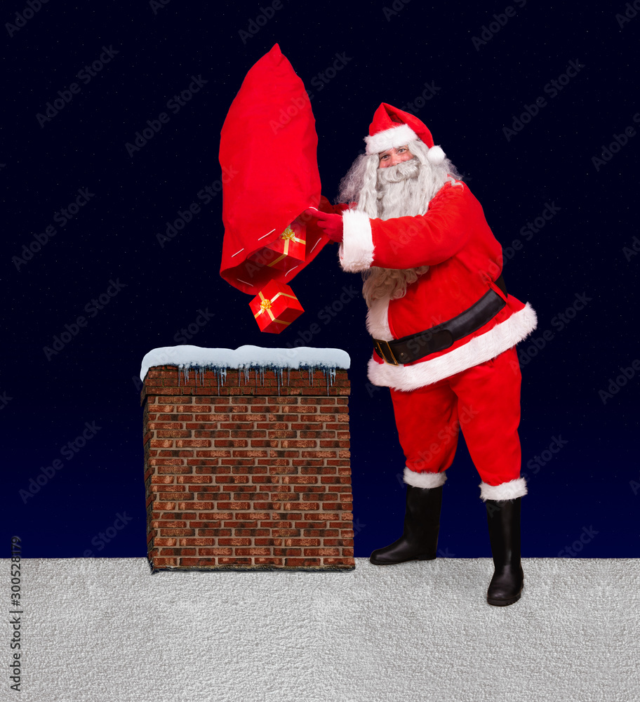 Santa Claus standing at a snowy roof and throw gifts from bag into the ...