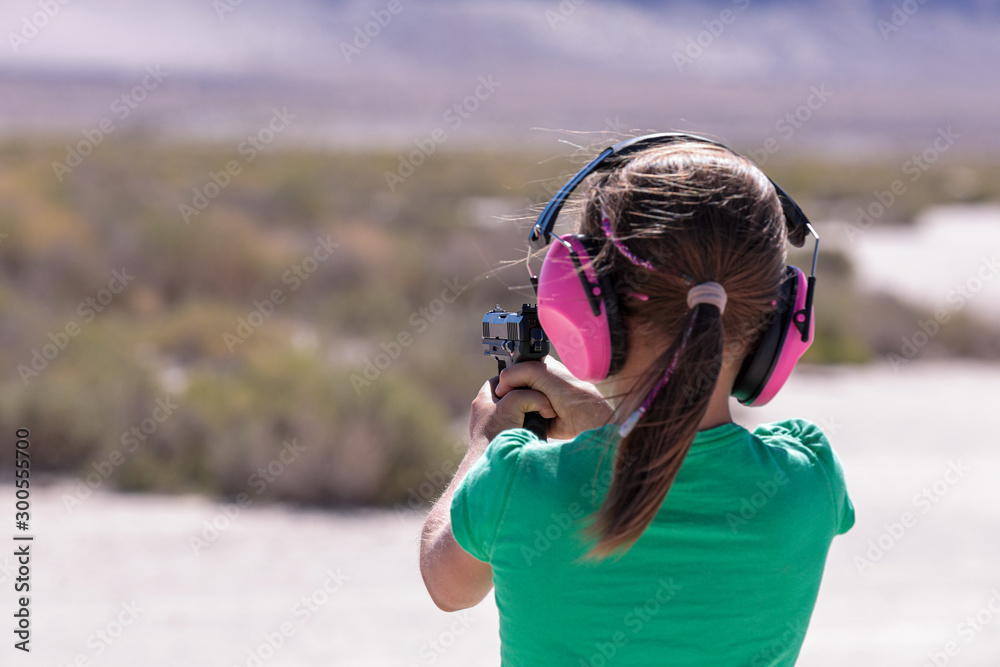 Little girl practicing target shooting with 22LR caliber pistol in ...