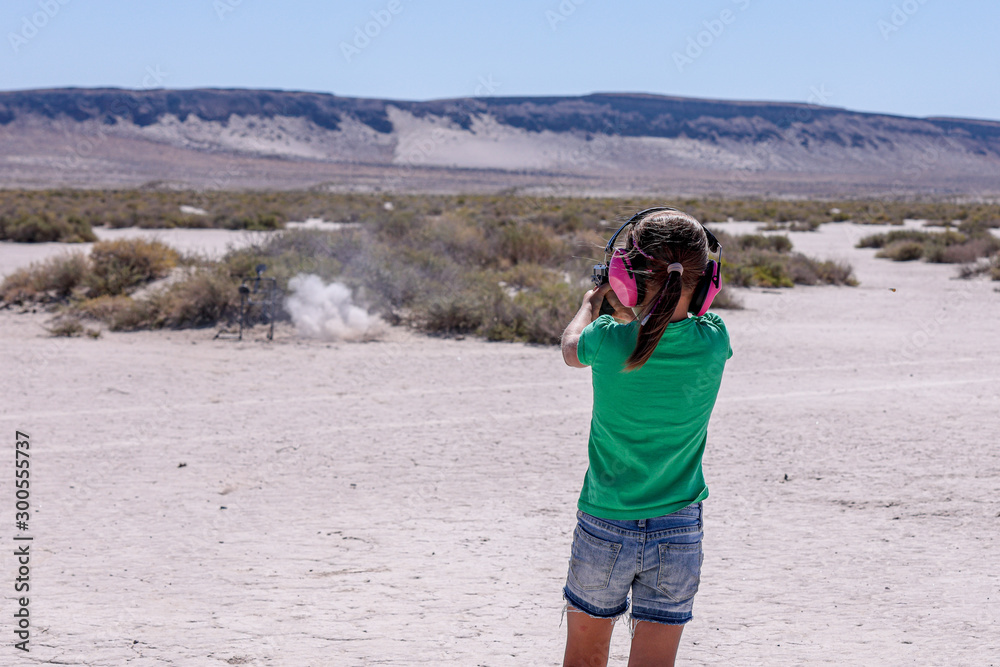 Little girl practicing target shooting with 22LR caliber pistol in ...
