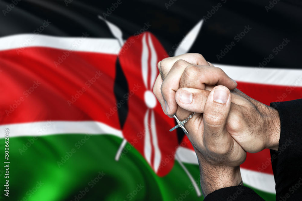 Kenya flag and praying patriot man with crossed hands. Holding cross ...