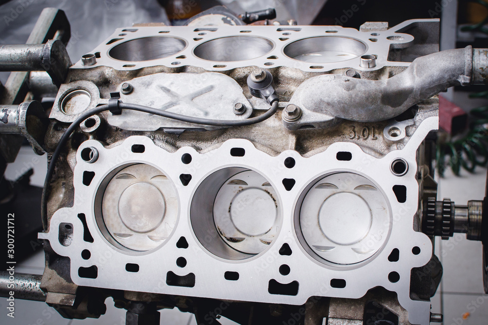 Parts of a disassembled car engine organised on the table for the ...
