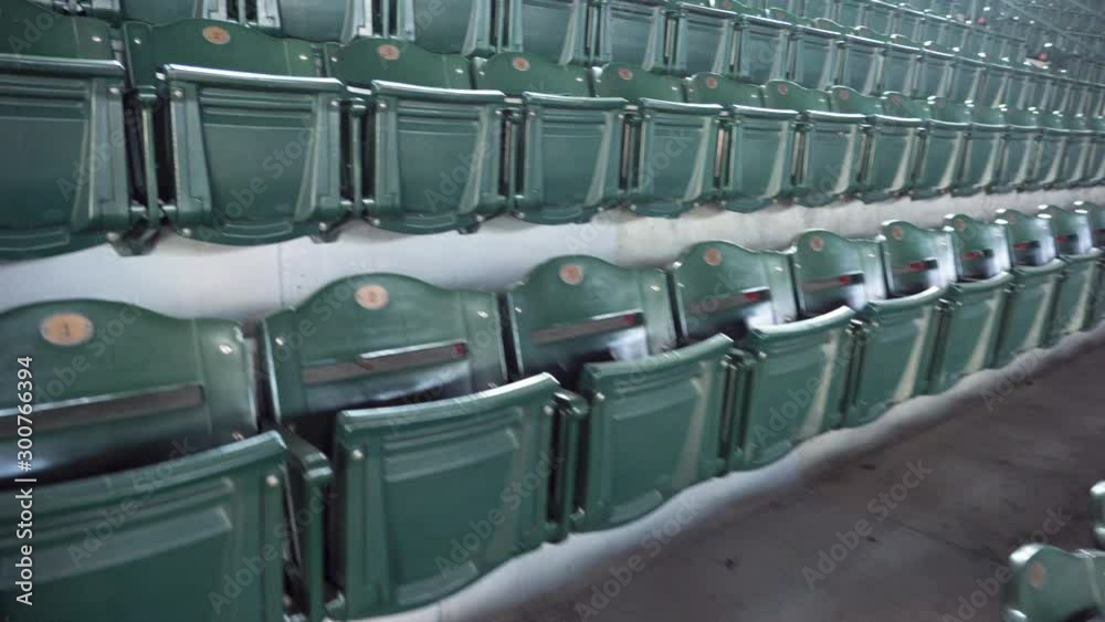 Walking Down Stairs in Indoor Stadium Seating with Empty Green fold up ...