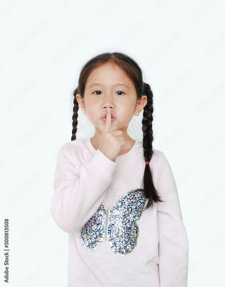 Portrait of caucasian little child girl with finger up to lips for ...