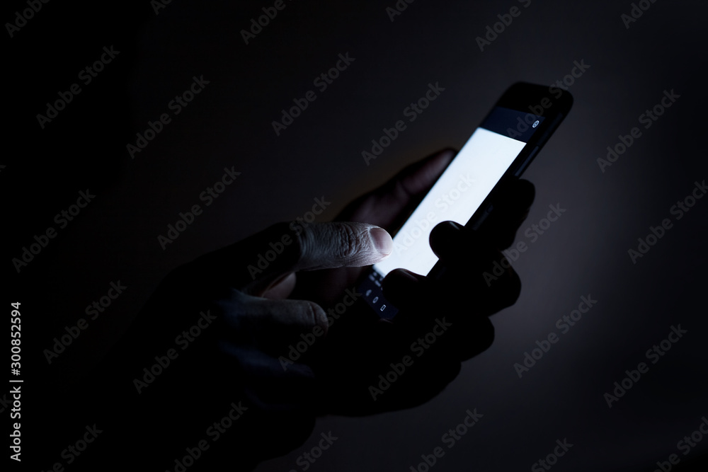 Anonymous holding smartphone in hands. Internet, cyber crime, telephone ...