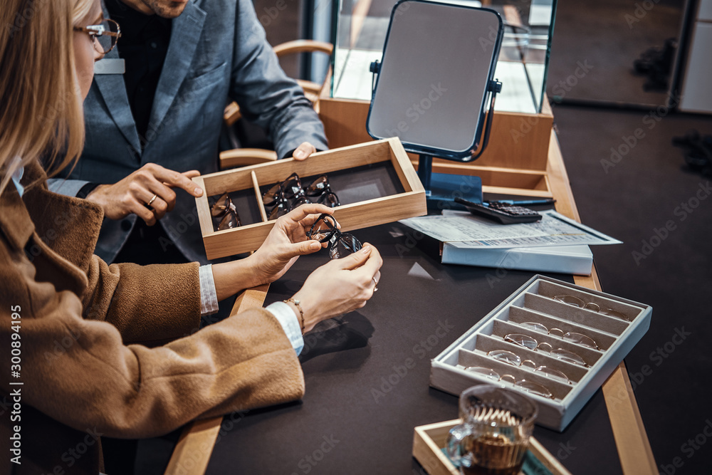 Female client is choosing new glasses with shop assistant help at ...