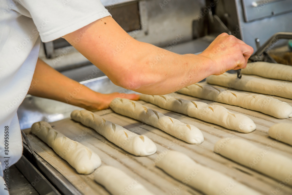 baker man gives razor cuts on the bread before baking Stock Photo ...