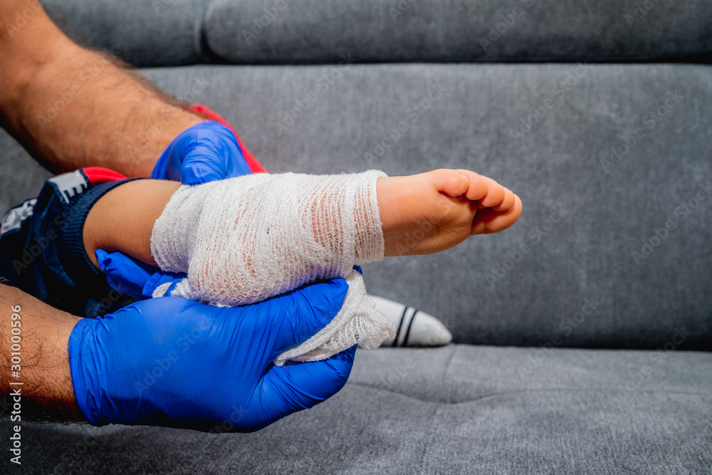 Bandaging of the child's foot. Health and pharmaceutical concept, child ...