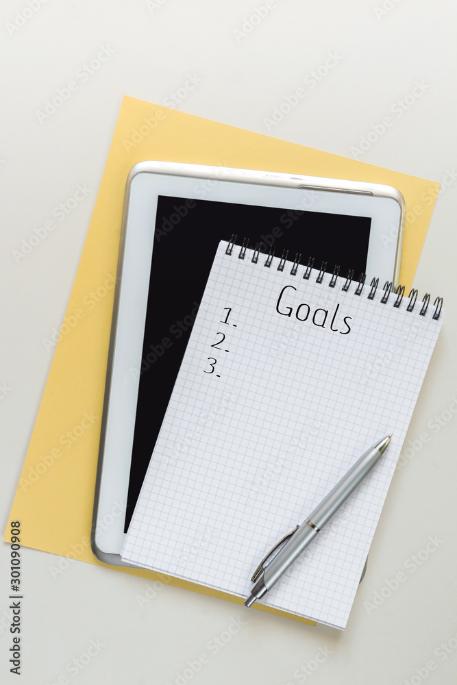 Top view of a flat lay of desktop and notepads for writing down goals ...