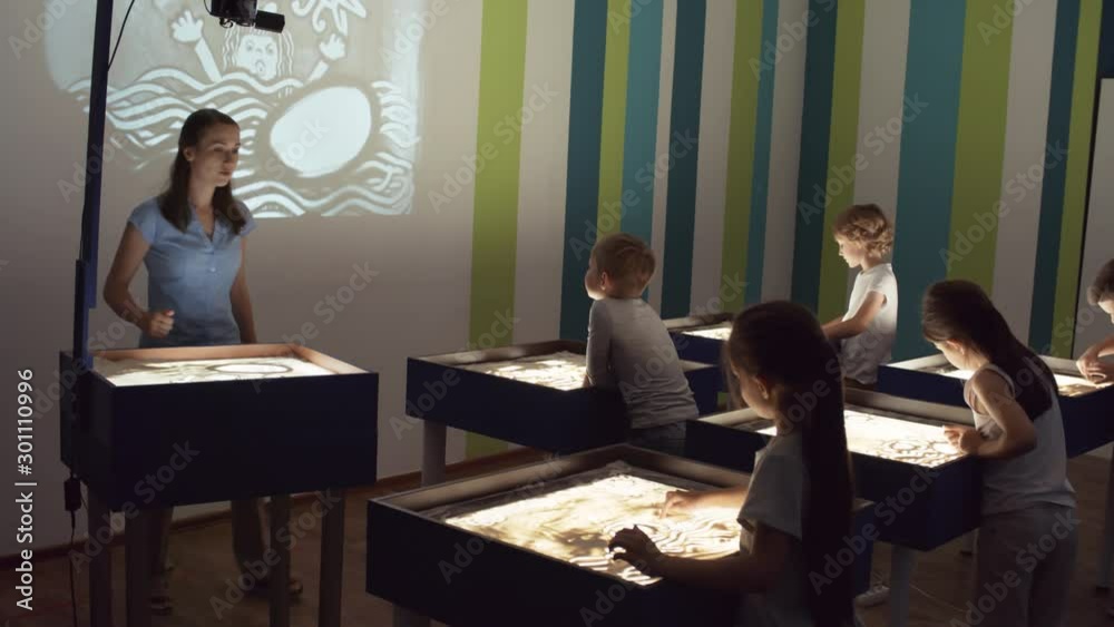 Video Stock Medium shot of young female art teacher using overhead ...