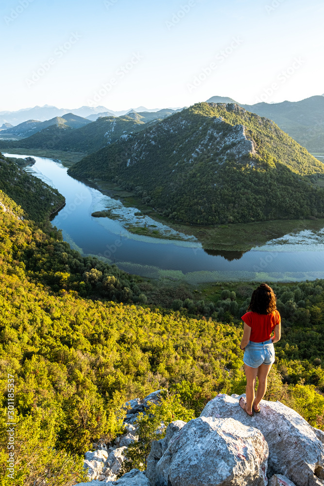 Lady looking over Lake Skadar in Montenegro during a beautiful sunset ...
