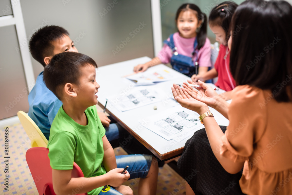 Asian elementary school children are studying in the classroom with an ...