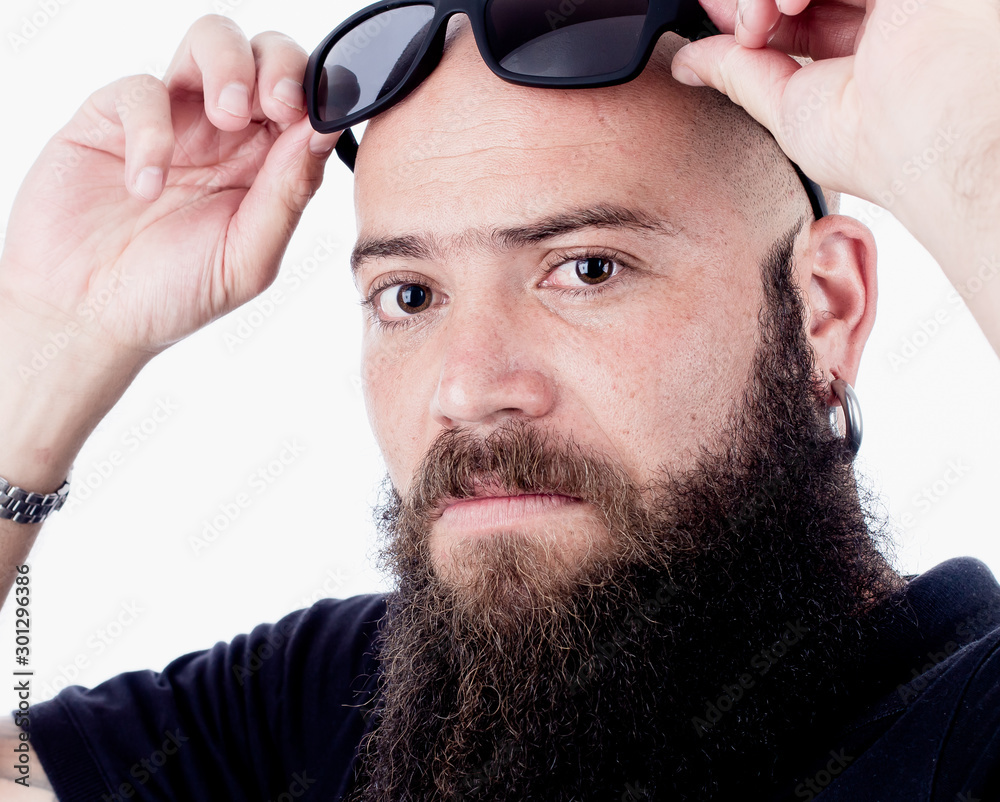 Um homem careca e de barba longa usando um brinco que está segurando um ...