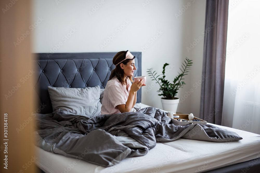 good morning concept - portrait of beautiful woman in pajamas sitting ...