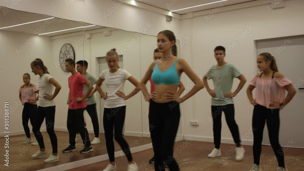 Cheerful teenage boys and girls dancing synchronous group choreography ...