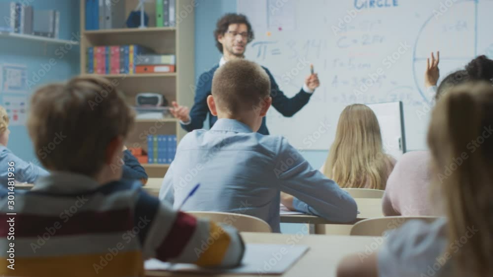 Teacher Explains Lesson to Diverse Classroom of Bright Children. In ...