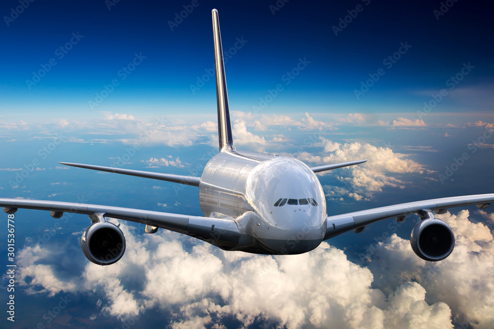 White aircraft in flight. The passenger plane flies high above the ...