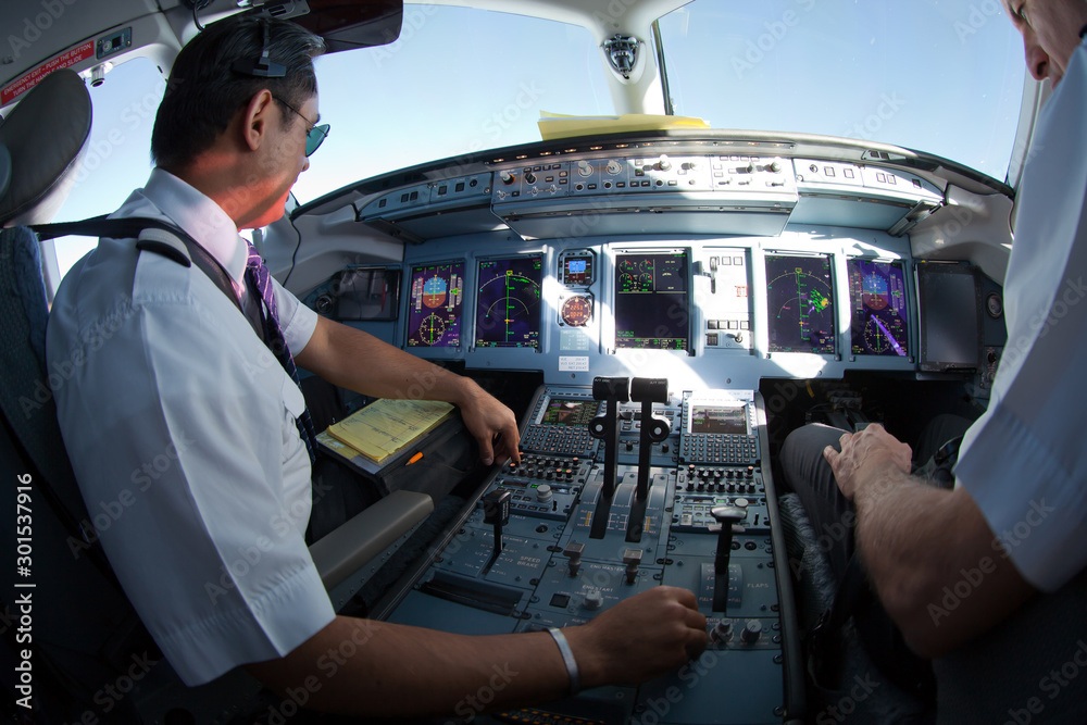 Cockpit of jet aircraft in flight. The pilots of the passenger plane at ...