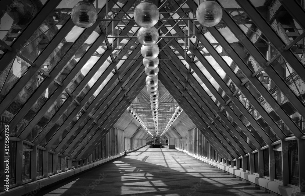Black and white image of a pedestrian bridge with a triangular roof and ...