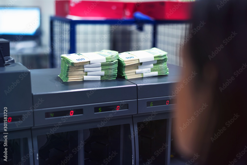Bank employees sorting and counting money inside bank vault. Large ...