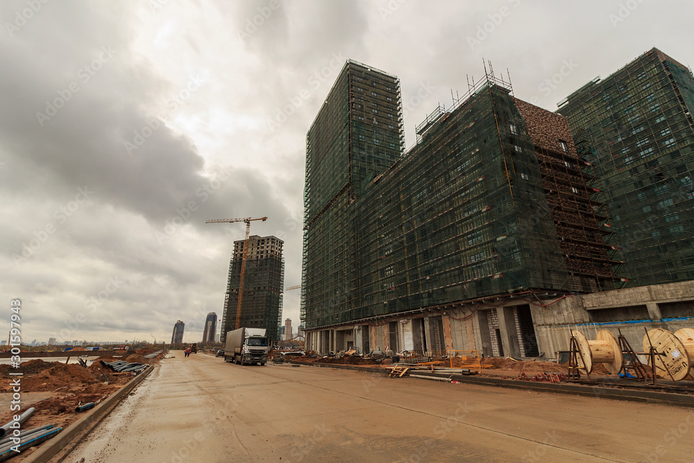 Tall building under construction with scaffolds. Construction site ...